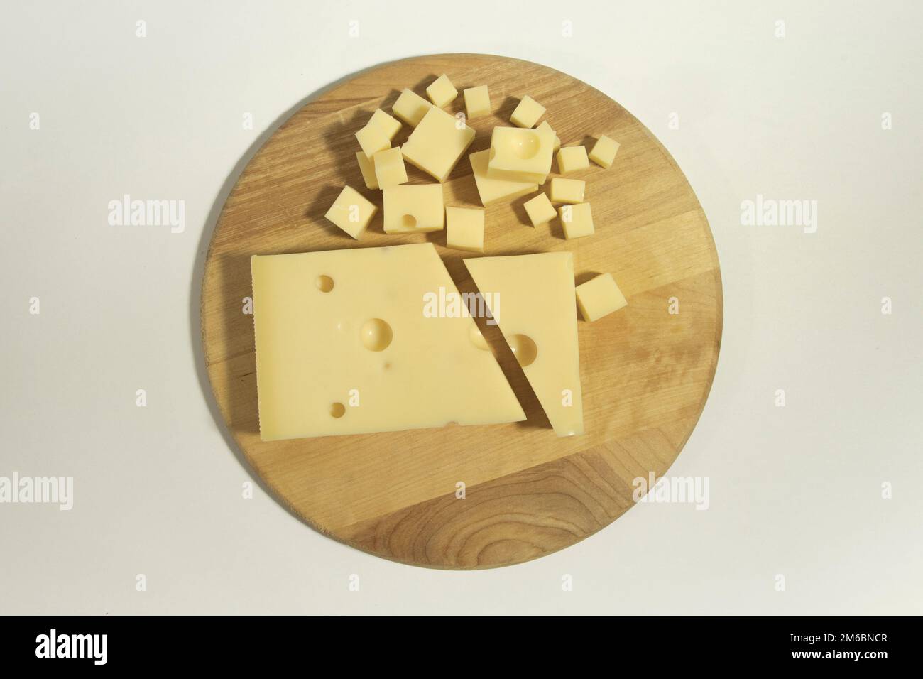 Emmental cheese close up on a cutting round board 03 Stock Photo - Alamy