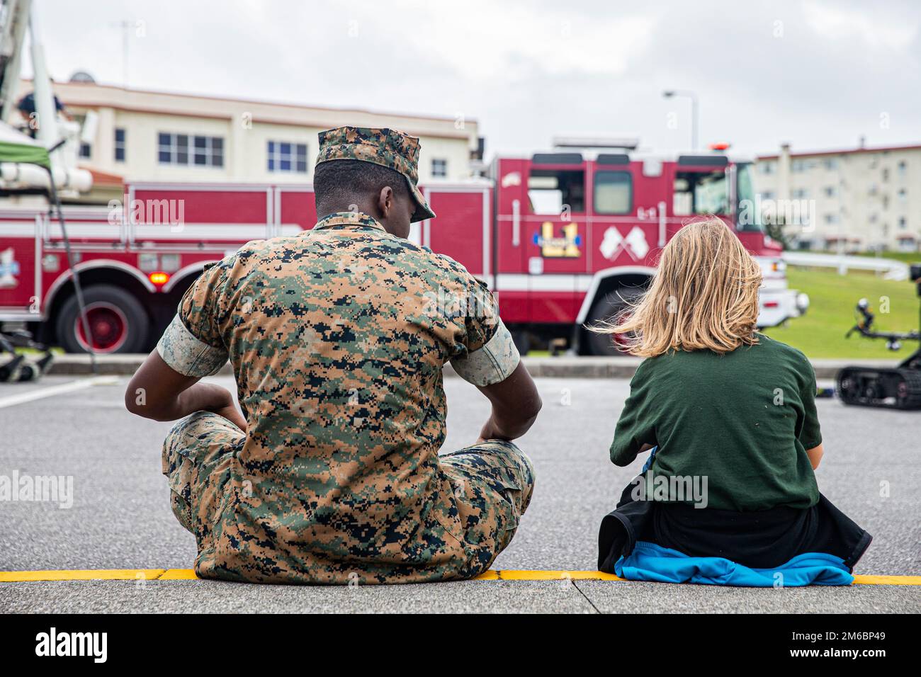 Service members and their families observe firefighters with Marine ...