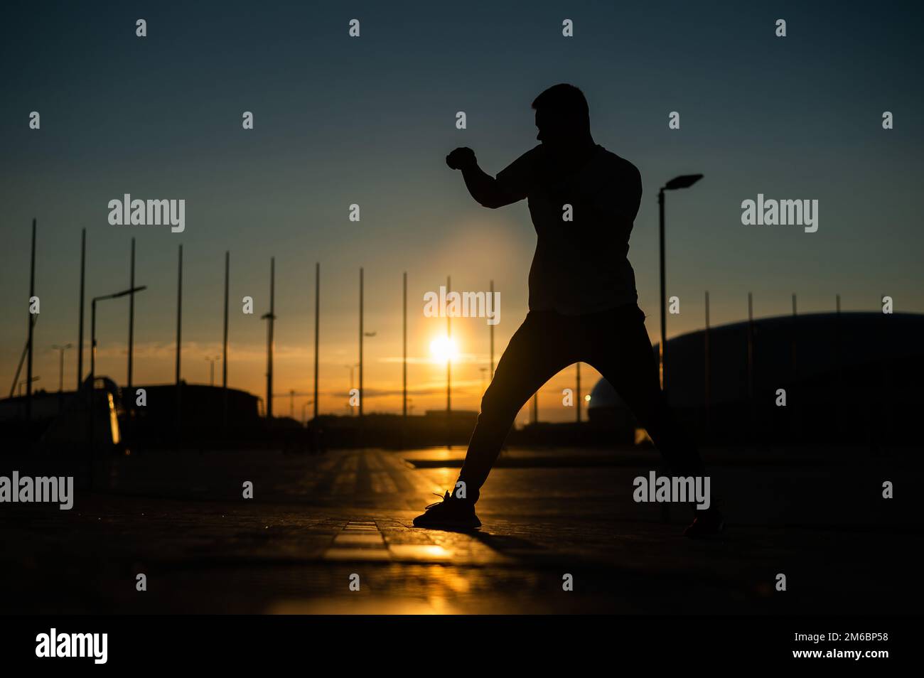 A man trains boxing at sunset outdoors Stock Photo - Alamy