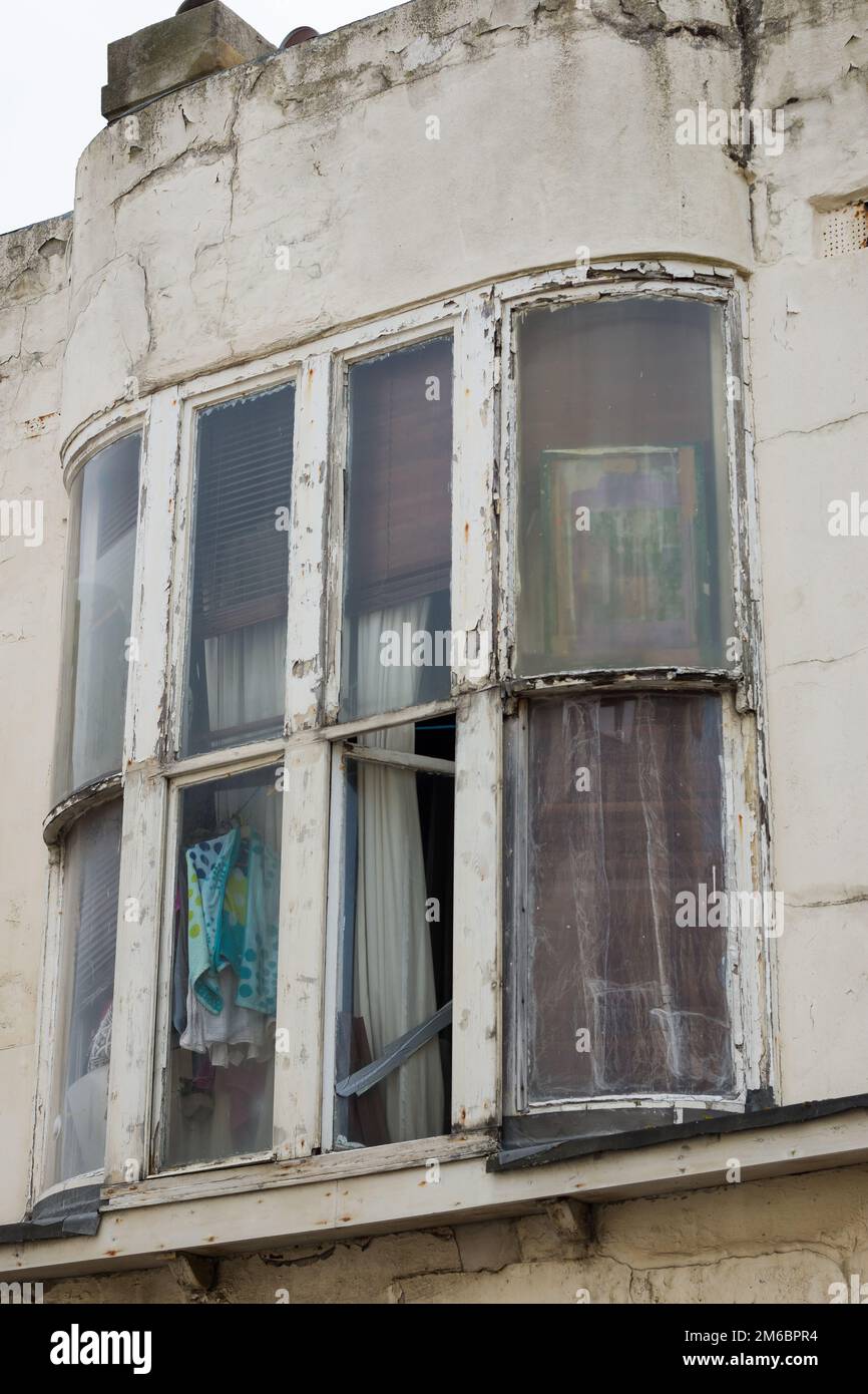 Neglected building with structural damage and broken window. View of ...