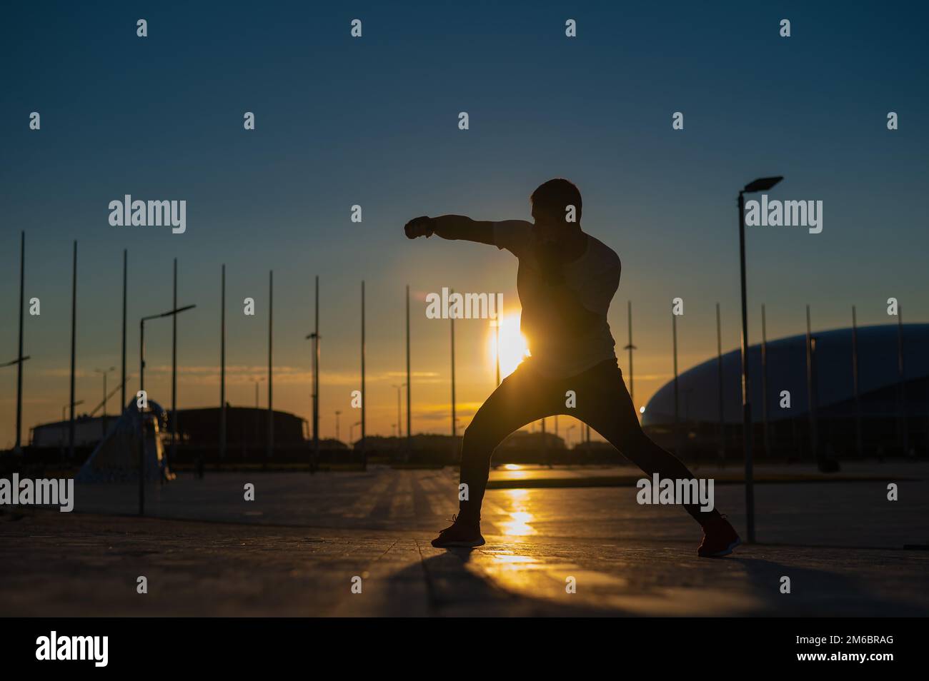 A man trains boxing at sunset outdoors Stock Photo - Alamy