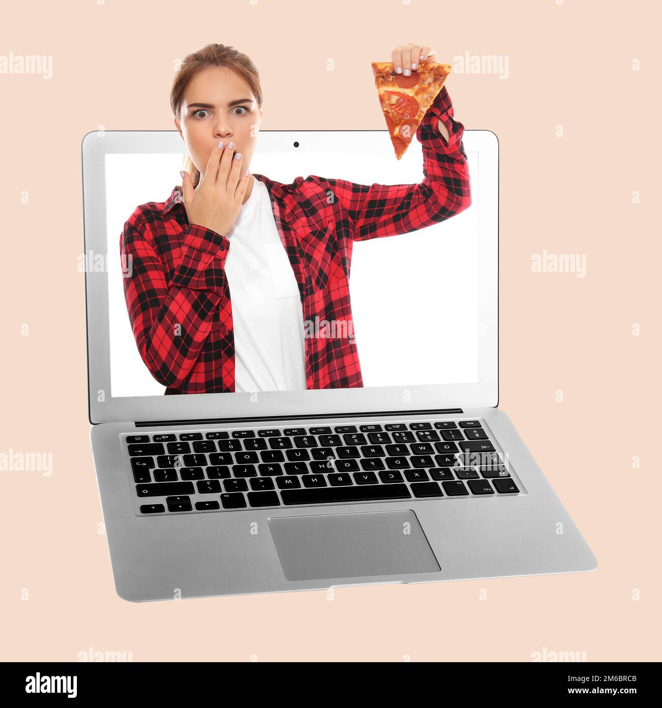 Shocked woman with slice of fresh pizza looking out of laptop screen on ...