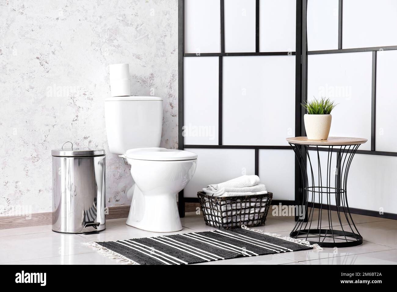 Interior of restroom with toilet bowl, table and folding screen Stock ...