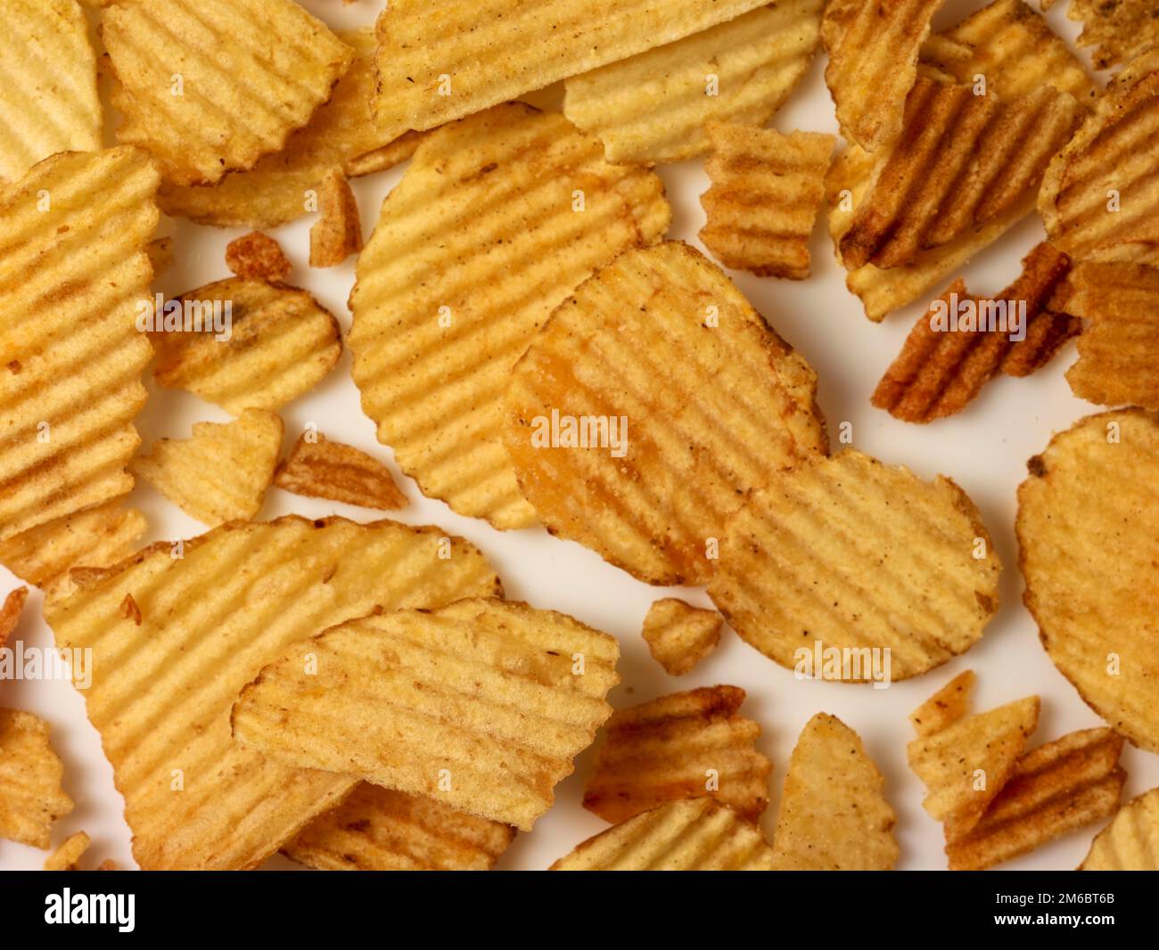 Food still life of potato crinkle cut crisps on plain background Stock ...