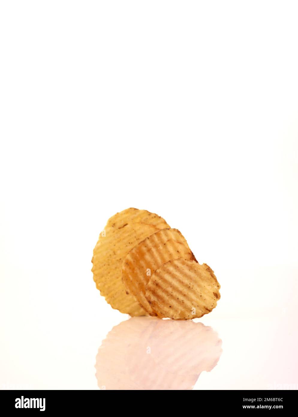 Food still life of potato crinkle cut crisps on plain background Stock ...