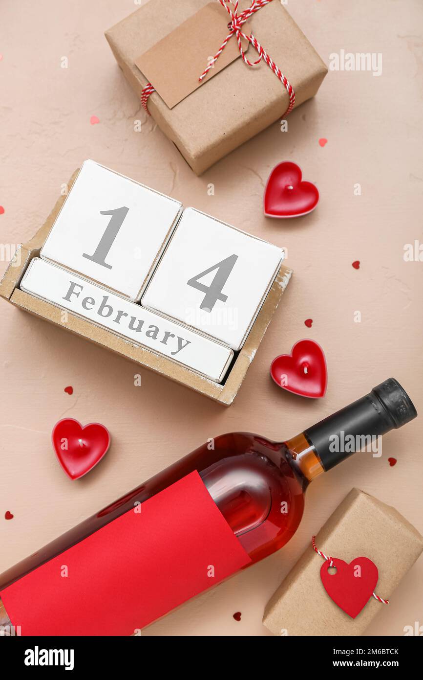 Cube calendar with date 14 FEBRUARY, gifts, wine bottle and candles on ...