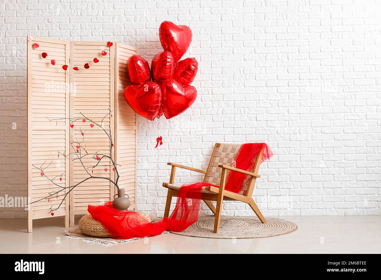 Interior of living room with chair, folding screen and red balloons for ...