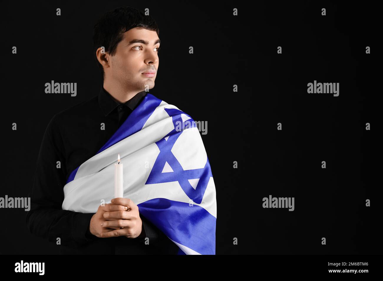 Jewish man with candle and flag of Israel honoring victims of Holocaust ...