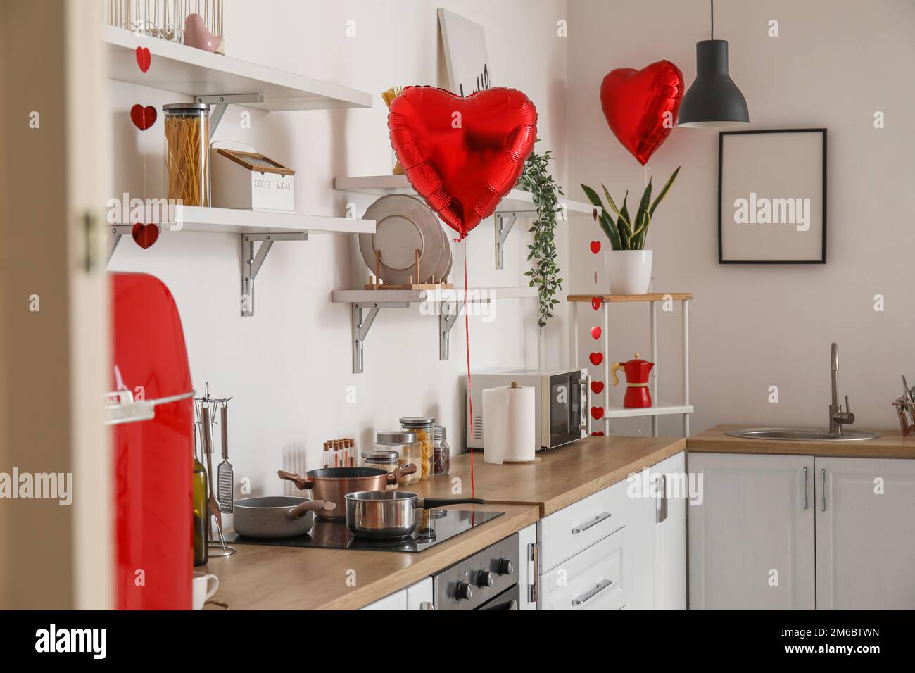 Interior of kitchen with counters, shelves and red balloons for ...