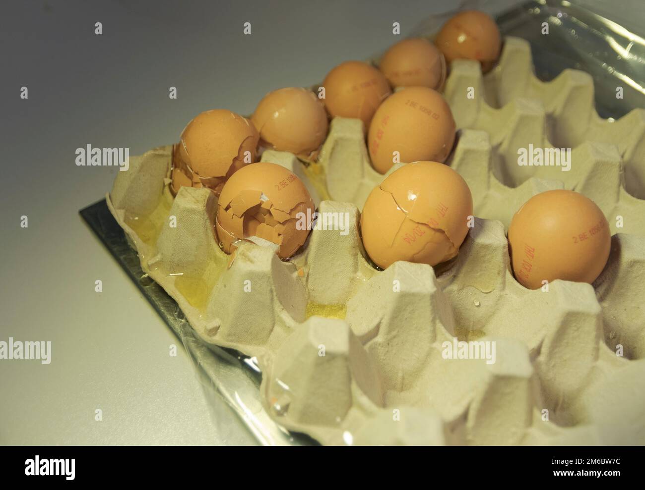 Broken eggs in an egg basket close up Stock Photo - Alamy