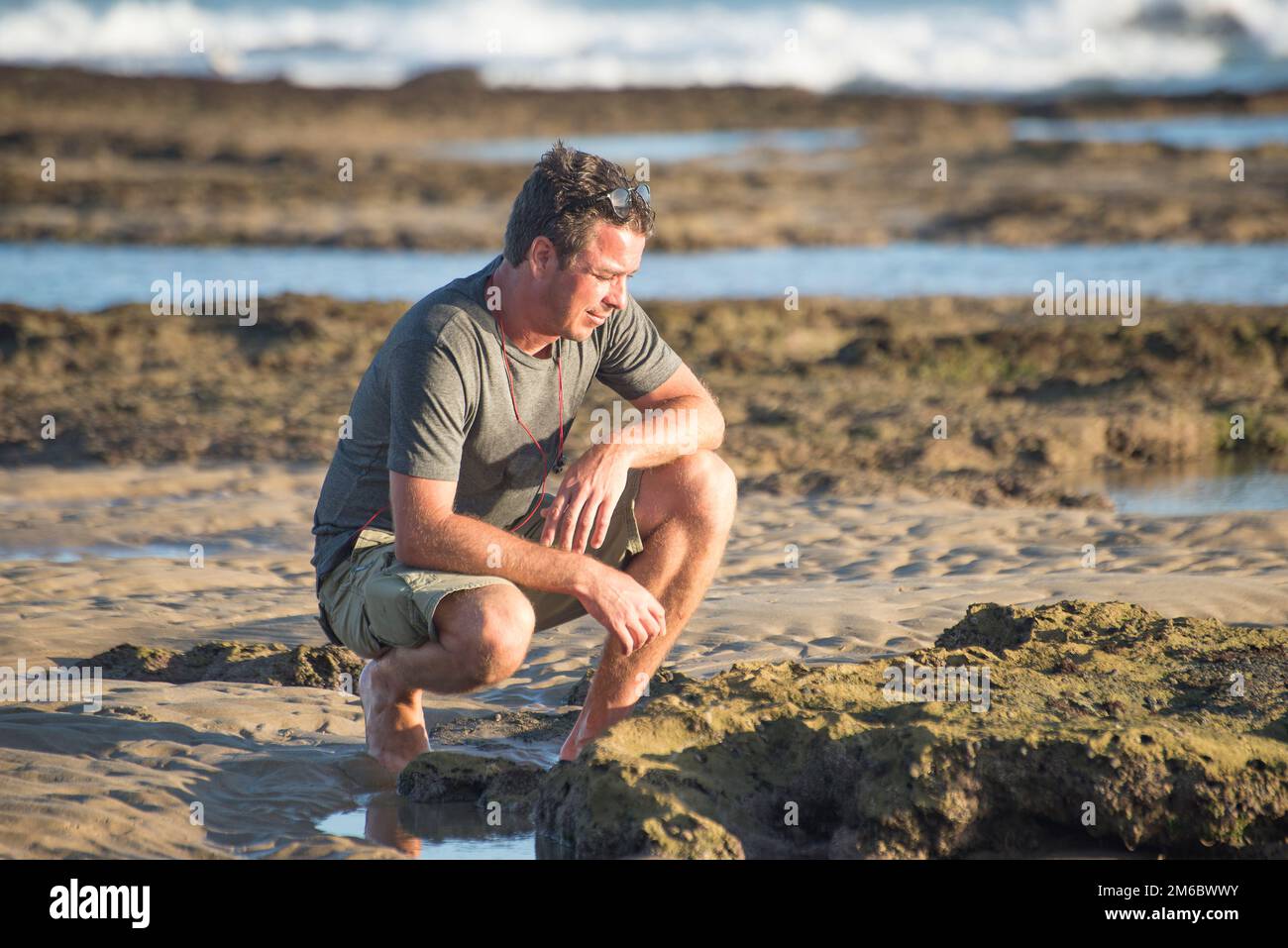 Man standing on rocks by ocean hi-res stock photography and images - Alamy