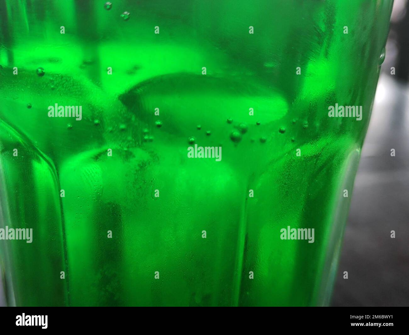 Green glass abstract background, close view. Green liquid with bubbles ...