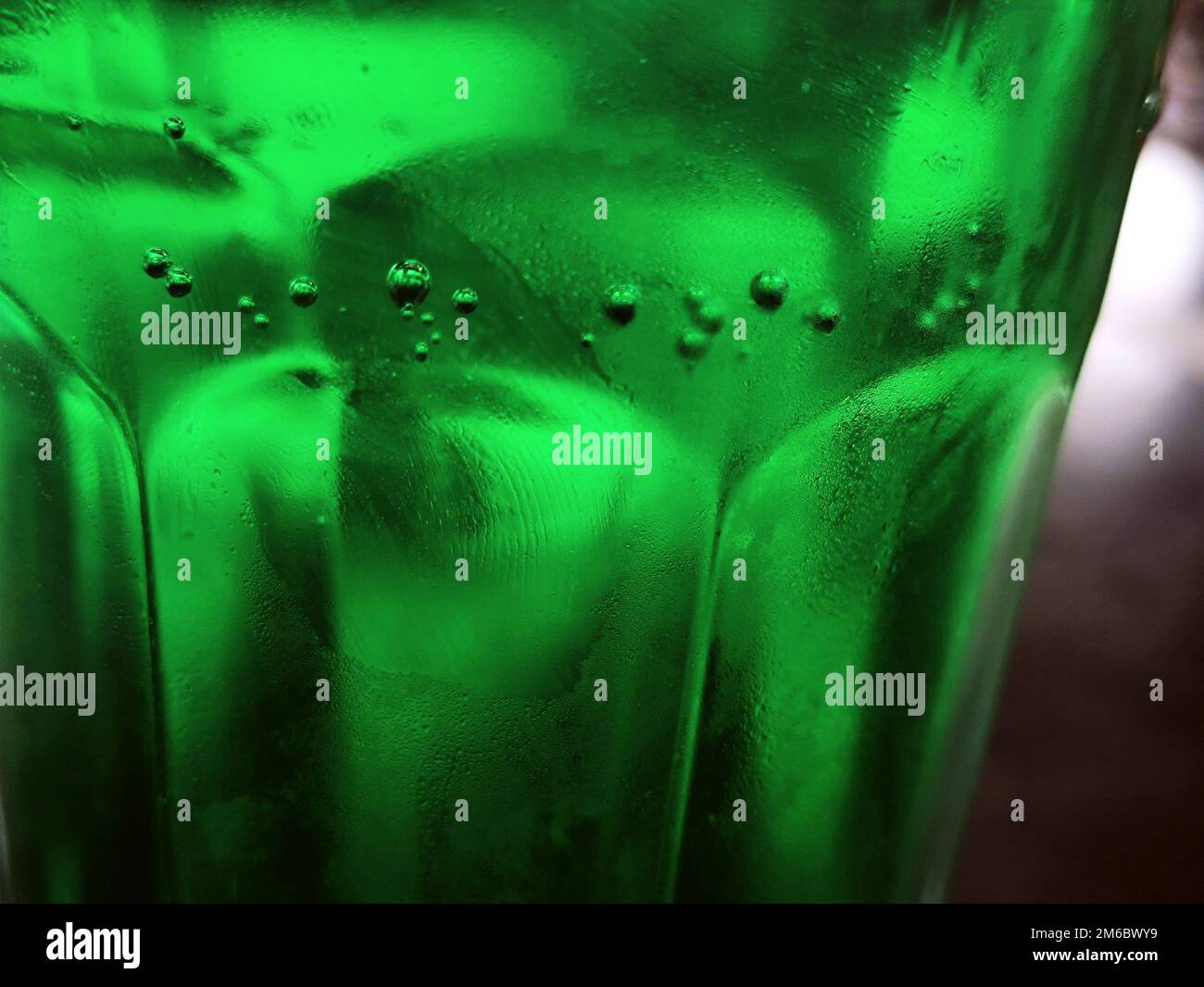 Green glass abstract background, close view. Green liquid with bubbles ...