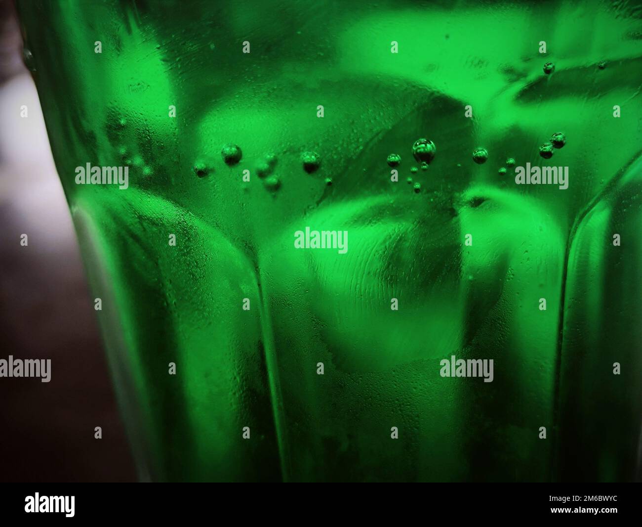 Green glass abstract background, close view. Green liquid with bubbles ...