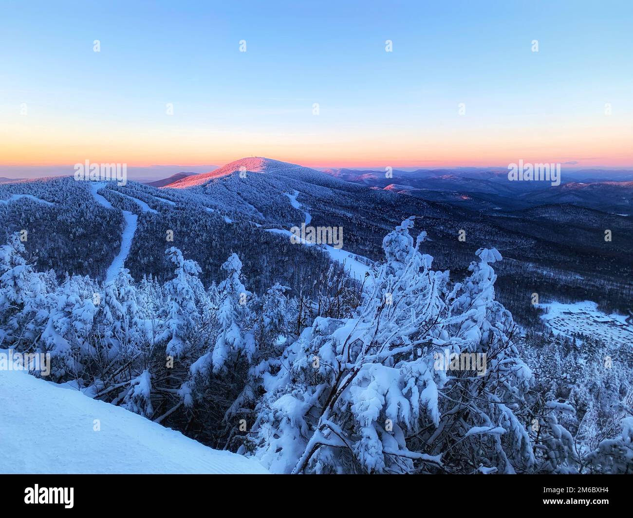 A scenic shot of hills covered with snowy trees in Killington Ski ...