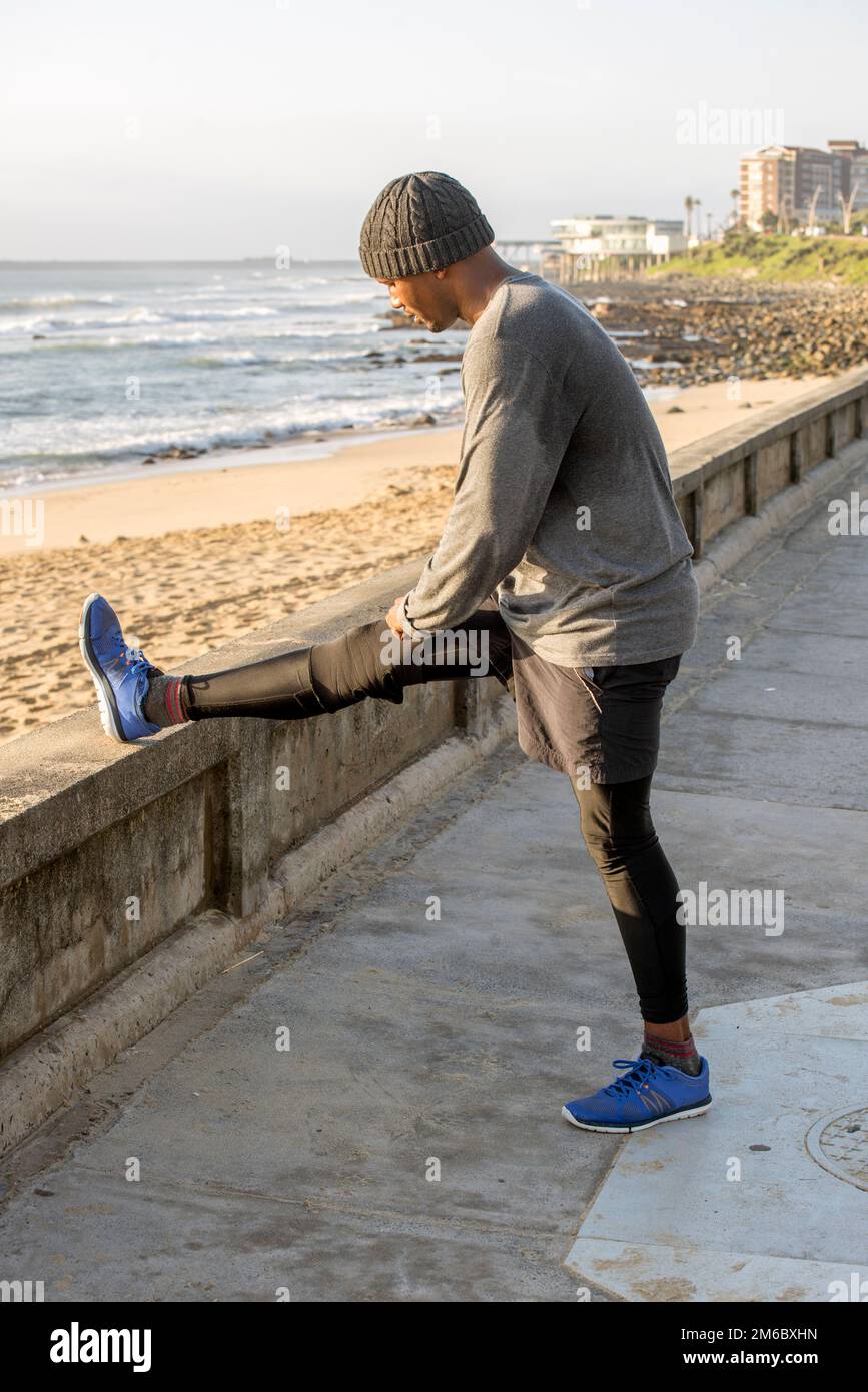Jogger Stretching on Promonade by beach Stock Photo - Alamy
