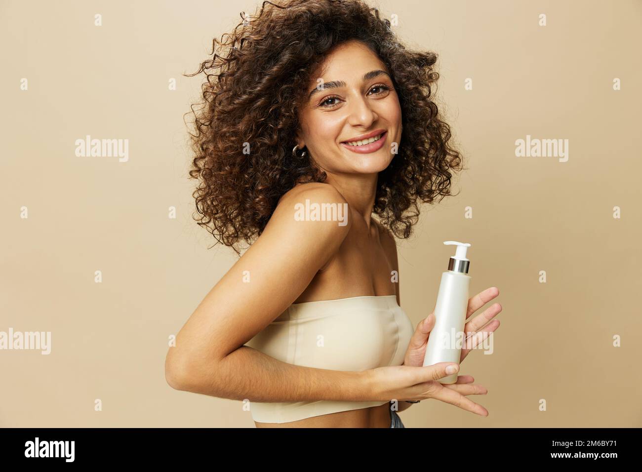 Woman applies cream and balm to her curly hair, the concept of ...