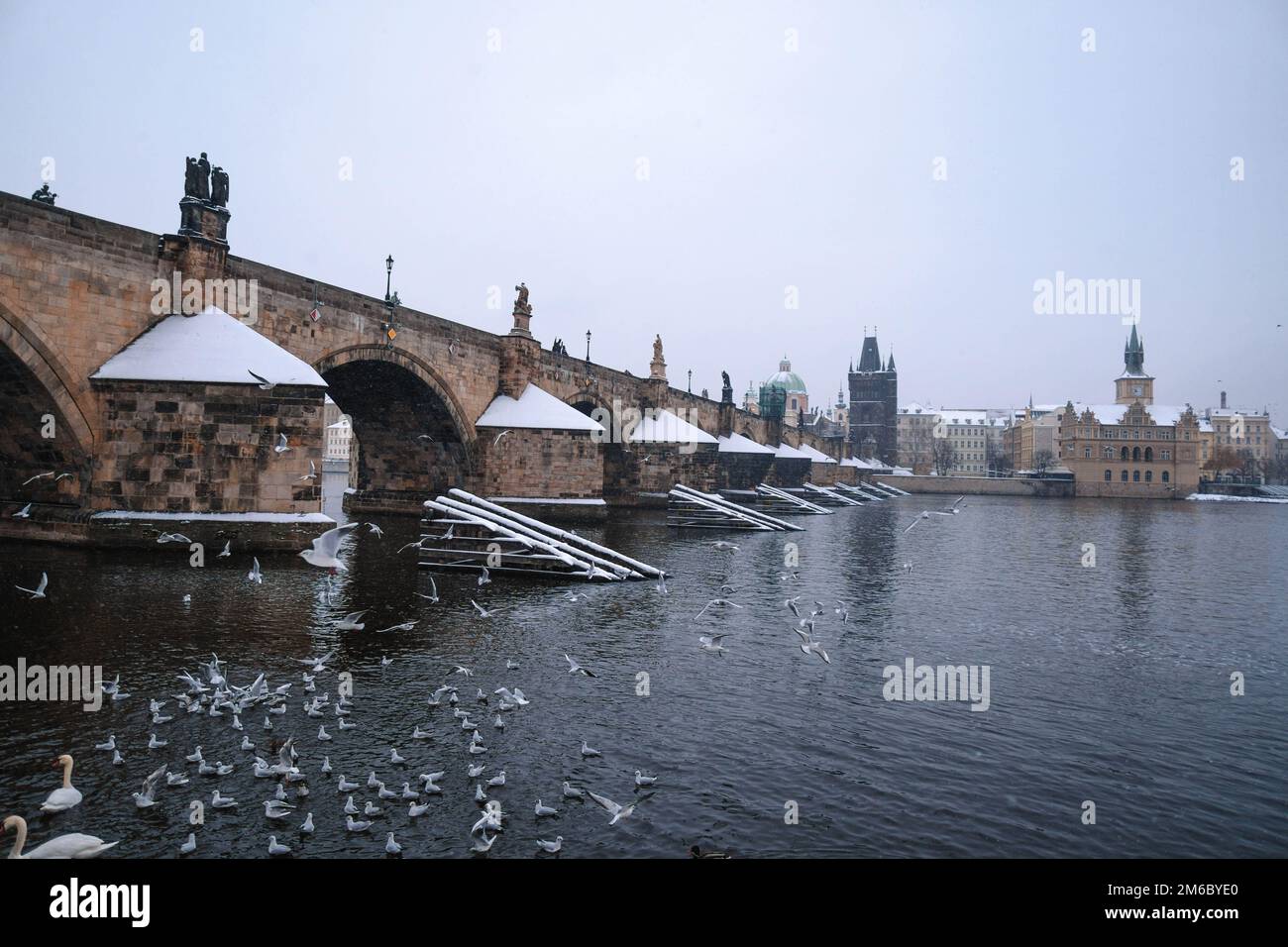 Prague in the snowfall. View of the Charles Bridge and the Vltava River ...