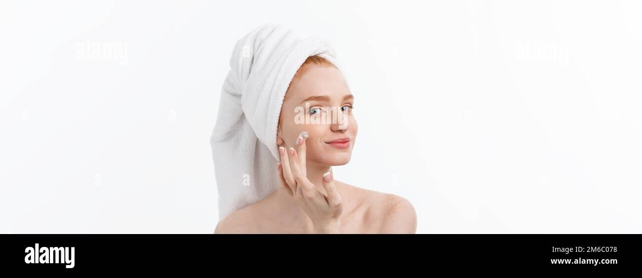 beautiful model applying cosmetic cream treatment on her face on white ...