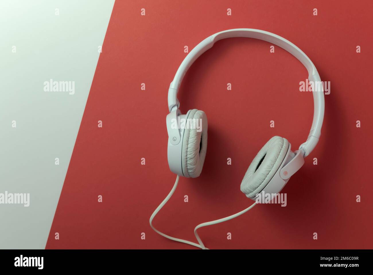 White headphones on a red-white background close Stock Photo - Alamy