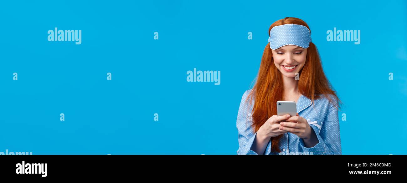 Mobile addication, technology and beauty concept. Cheerful girl waking up and grab phone ...