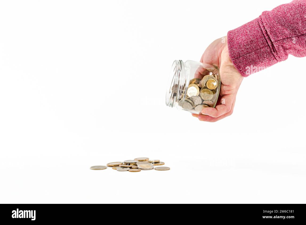 Man pour out of coin money to the floor on white background. Woman ...