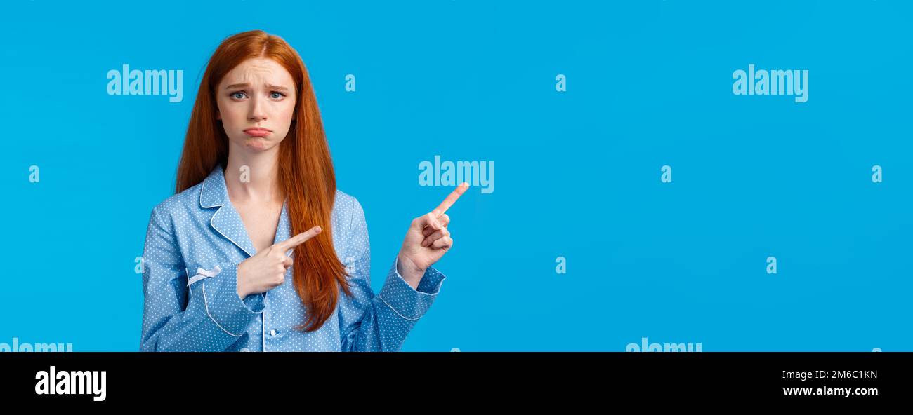 Sad sulking cute teenage girl with red hair asking parents something on ...