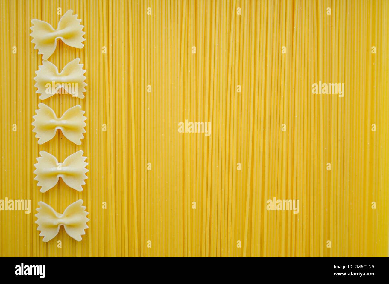 Uncooked pasta spaghetti macaroni yellow background, textured Stock ...