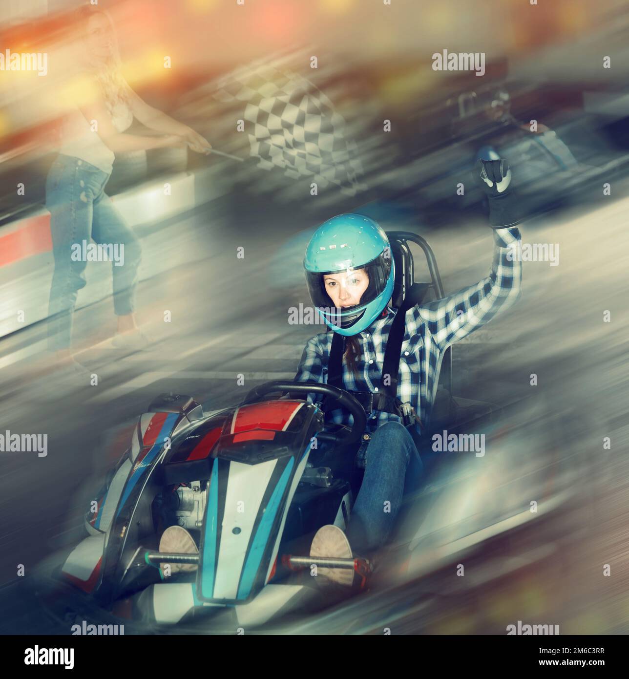 Glad female go-cart racer crossing finish line Stock Photo - Alamy