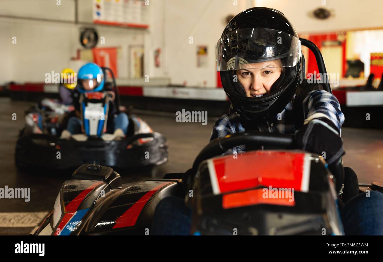 Female racer in helmet driving kart on track Stock Photo - Alamy
