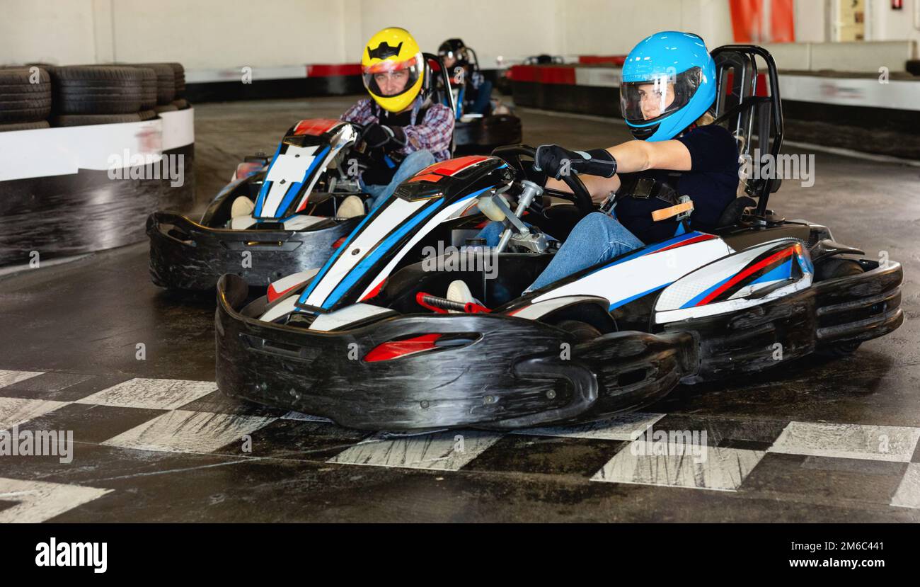 Group of people driving go-carts at racing track Stock Photo - Alamy