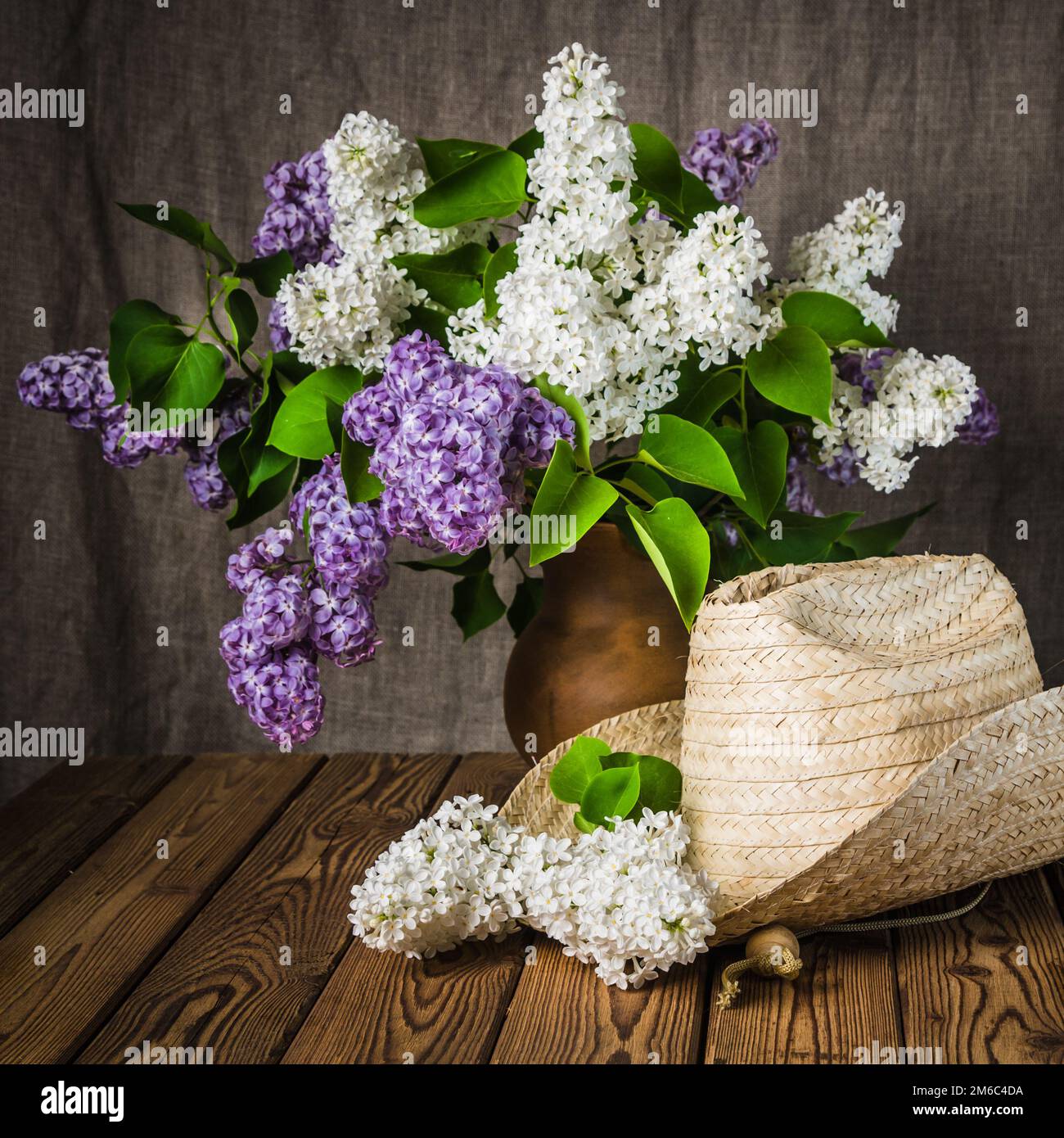 Still-life with a bouquet of lilacs and a straw hat, close-up Stock ...