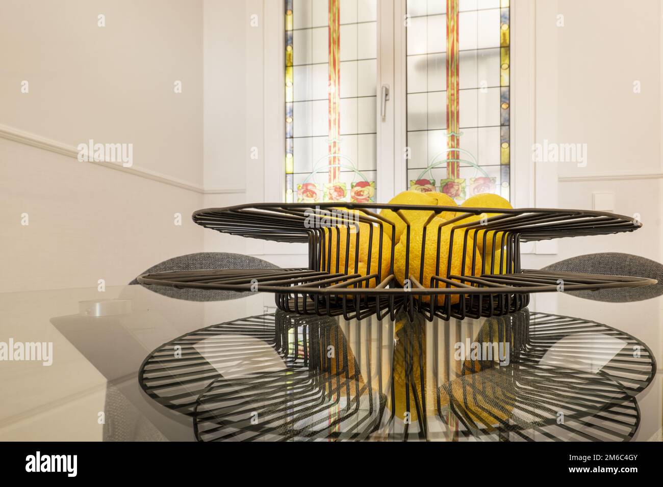 Modern centerpiece of black wire with oranges and lemons on a glass ...