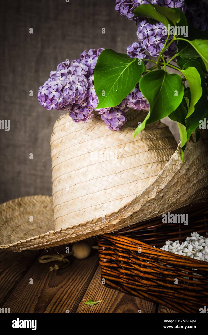 Still-life with a bouquet of lilacs and a straw hat, close-up Stock ...