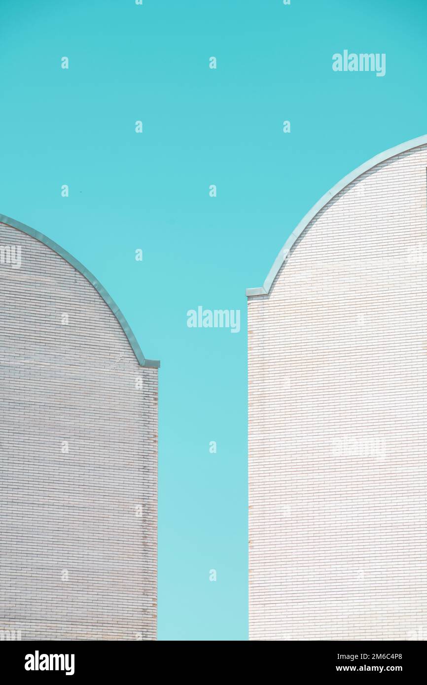 Twin facades of twin white brick buildings with clear blue sky Stock ...