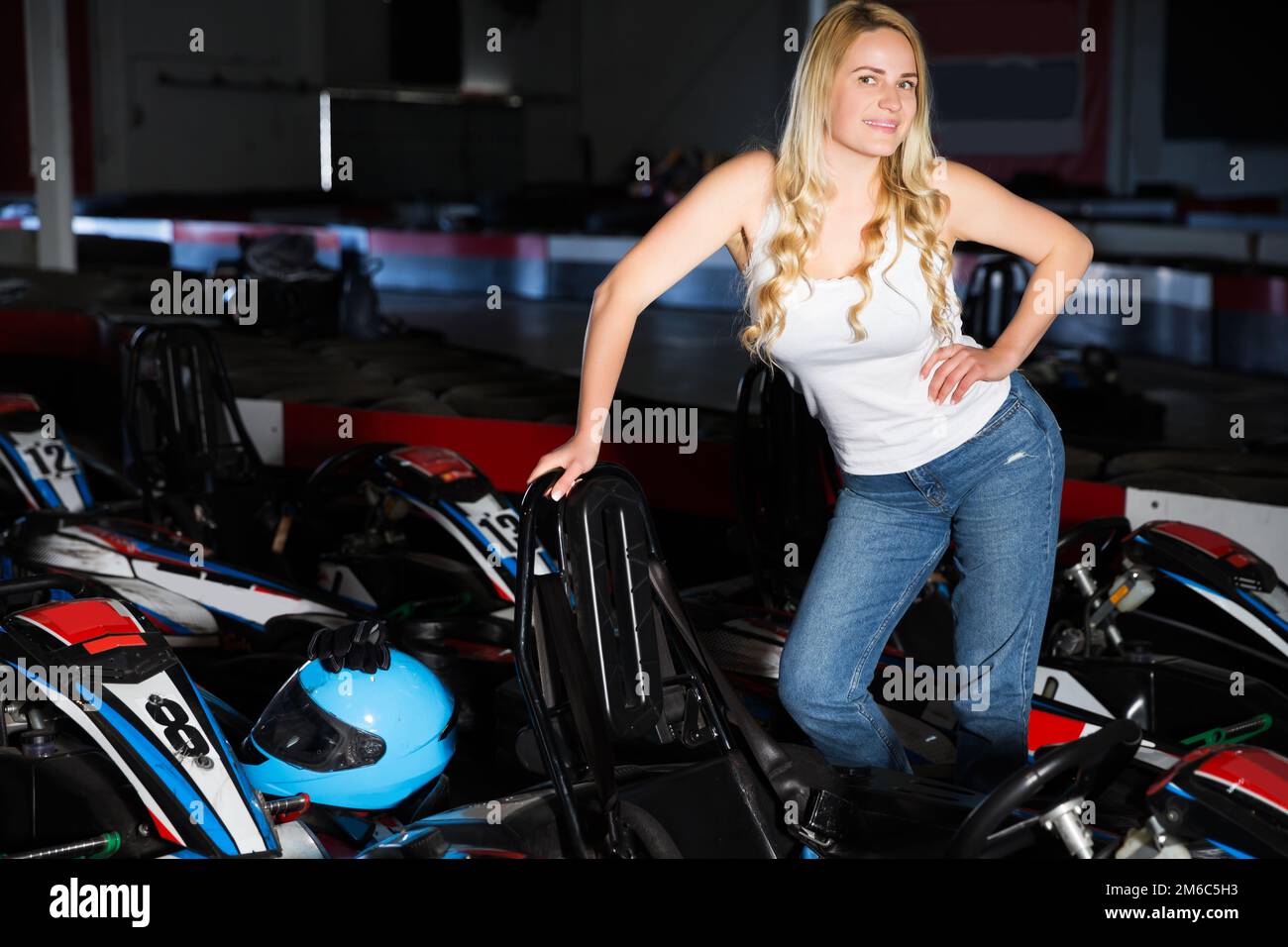 Positive female model posing near racing cars Stock Photo - Alamy