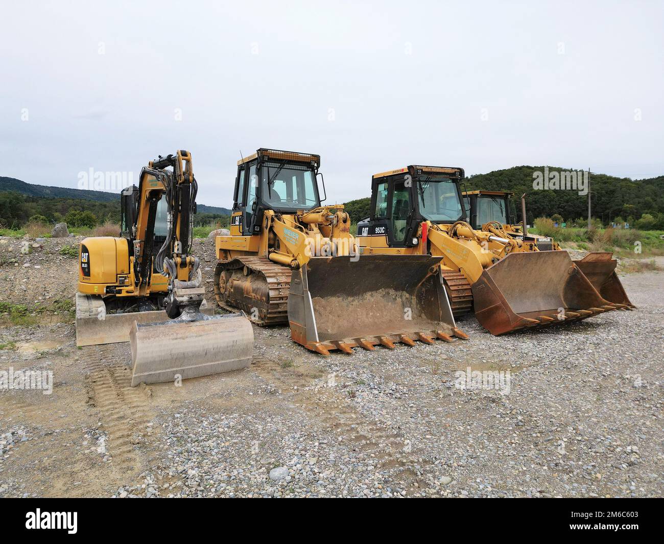 A closeup view of backhoe loaders on a gravel road Stock Photo - Alamy