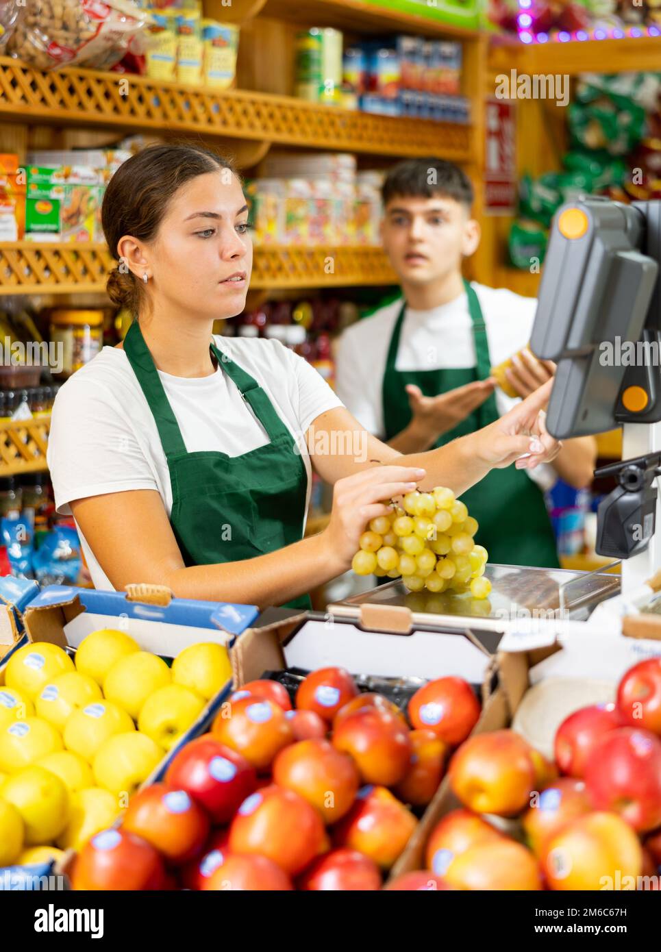 Female shopping assistant weighing grapes in grocery shop Stock Photo ...