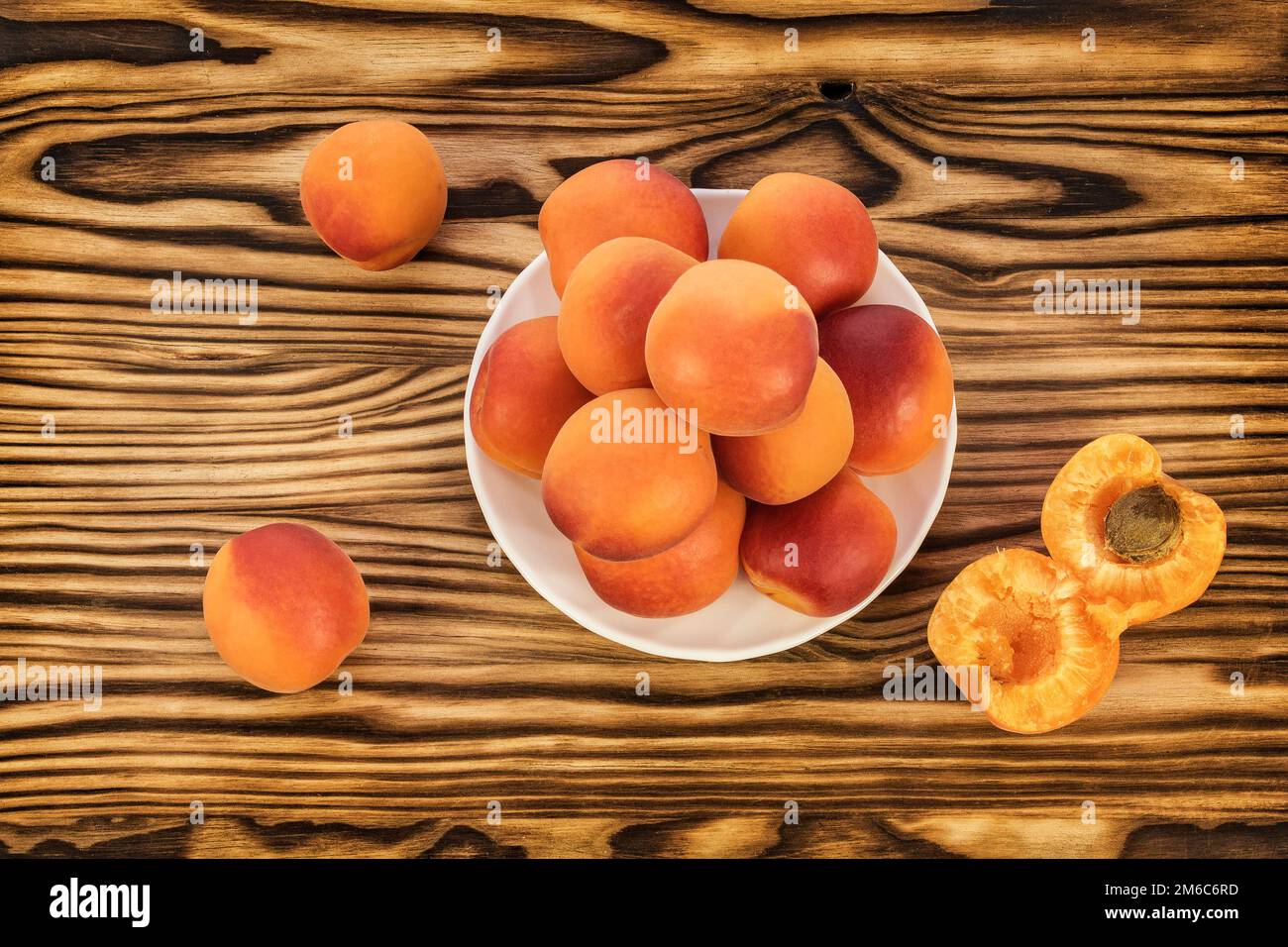 On the table and on a white saucer lie ripe apricots Stock Photo - Alamy