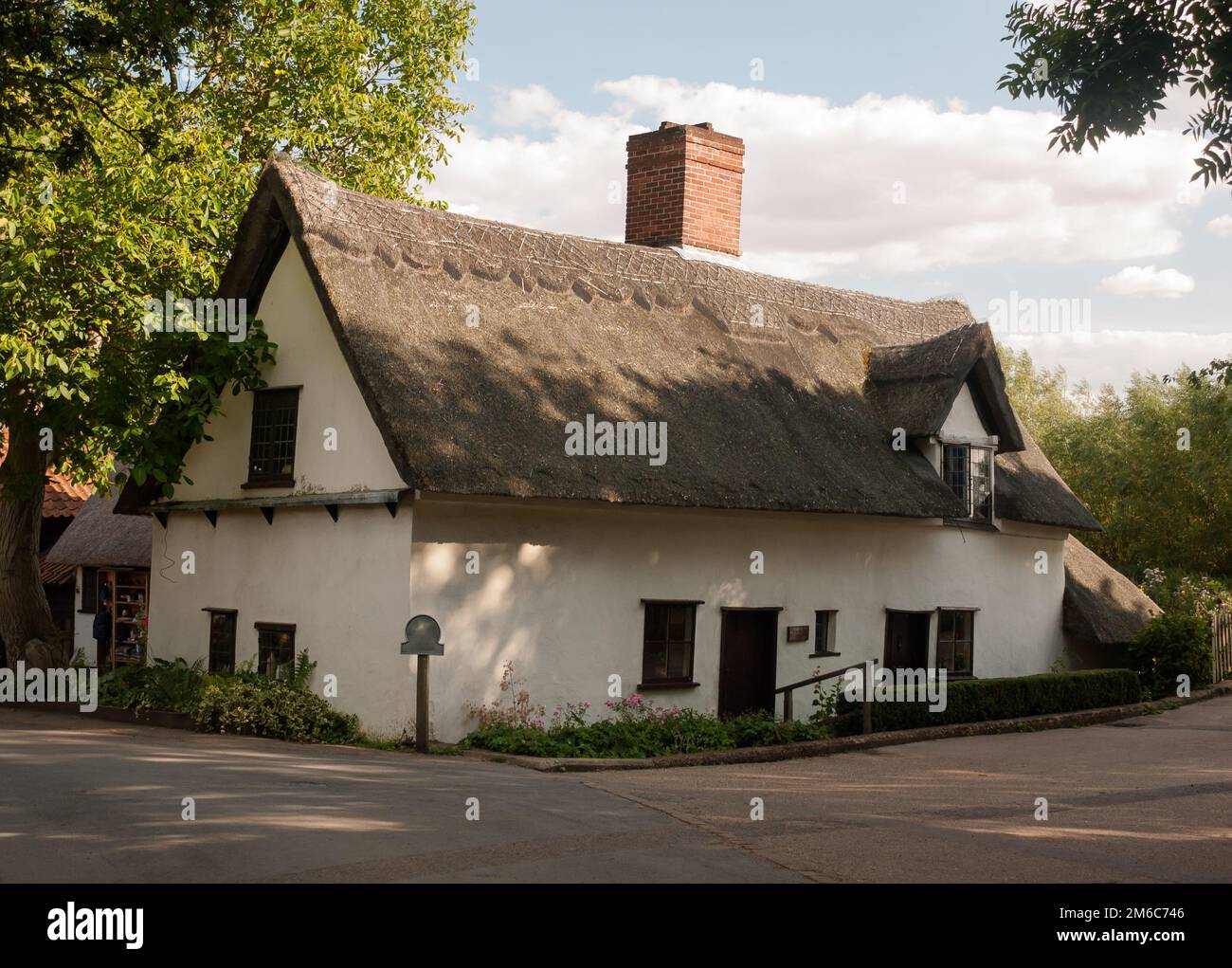 An old white barn cottage with thatched roof in summer light Stock ...
