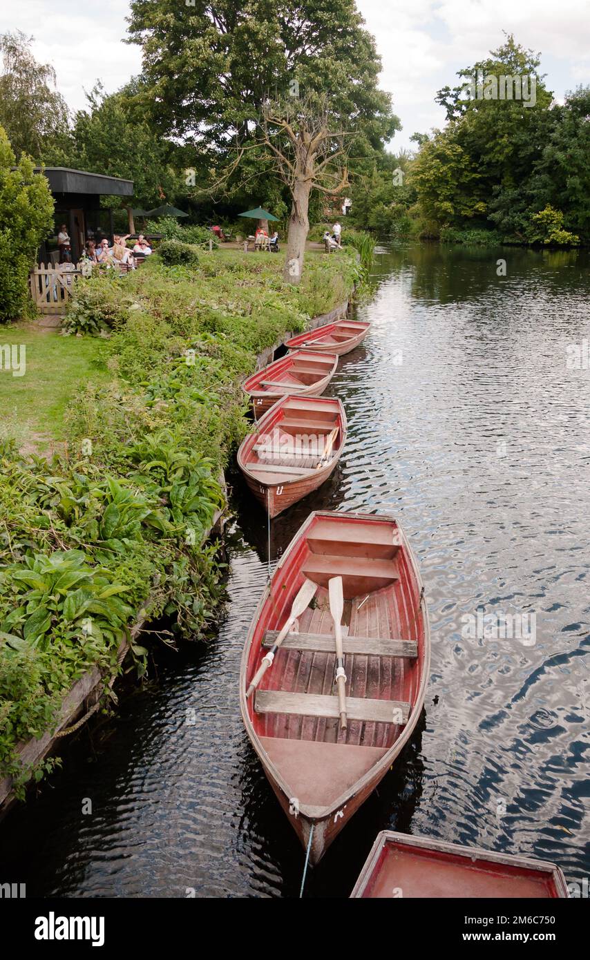 A row of parked wooden rowing boats on river country Stock Photo - Alamy