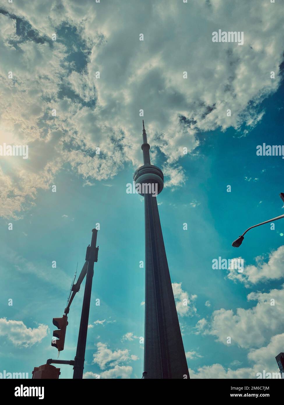 A vertical low angle shot of the beautiful CN tower against a blue ...