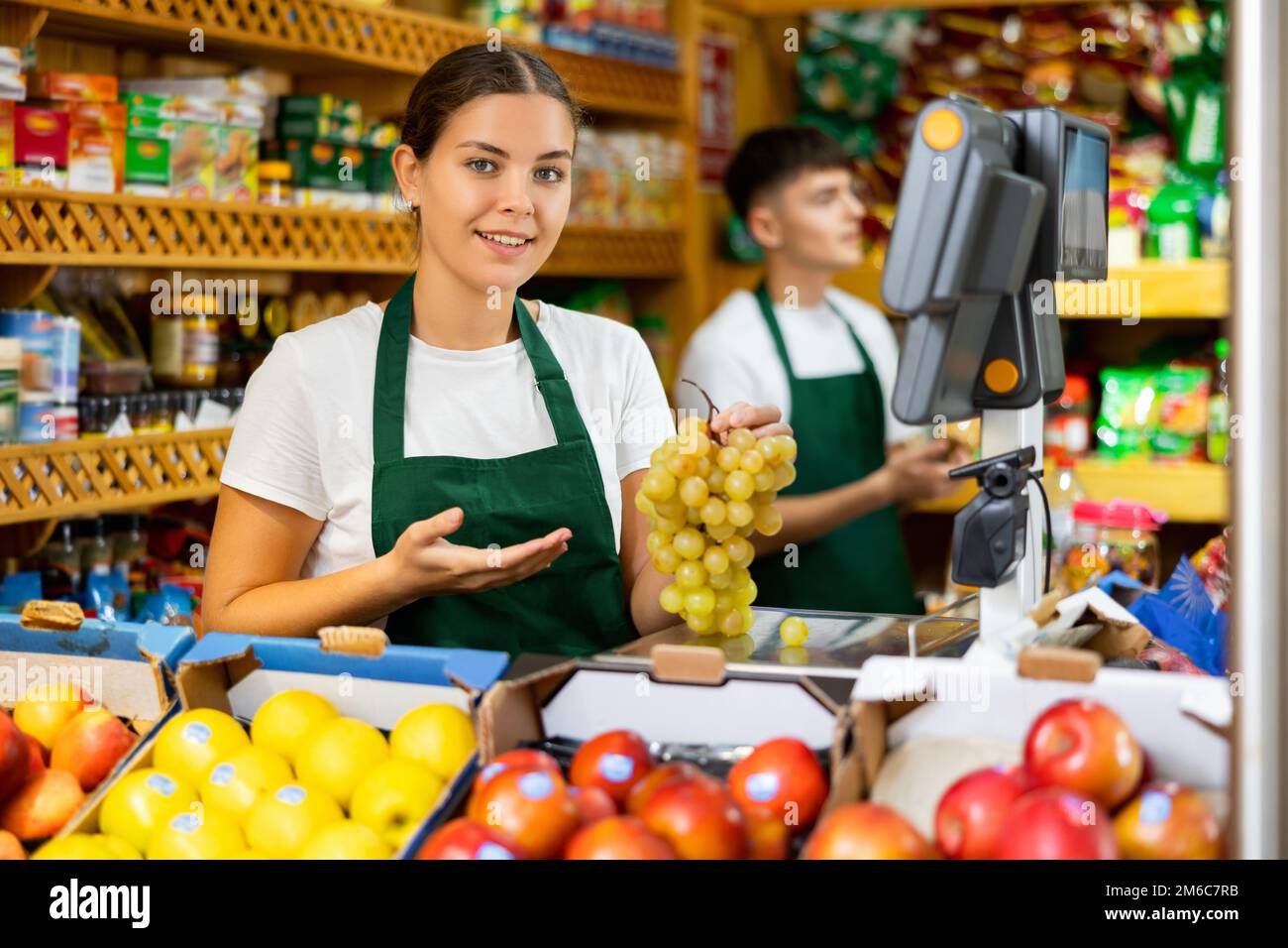 Female shopping assistant weighing grapes in grocery shop Stock Photo ...