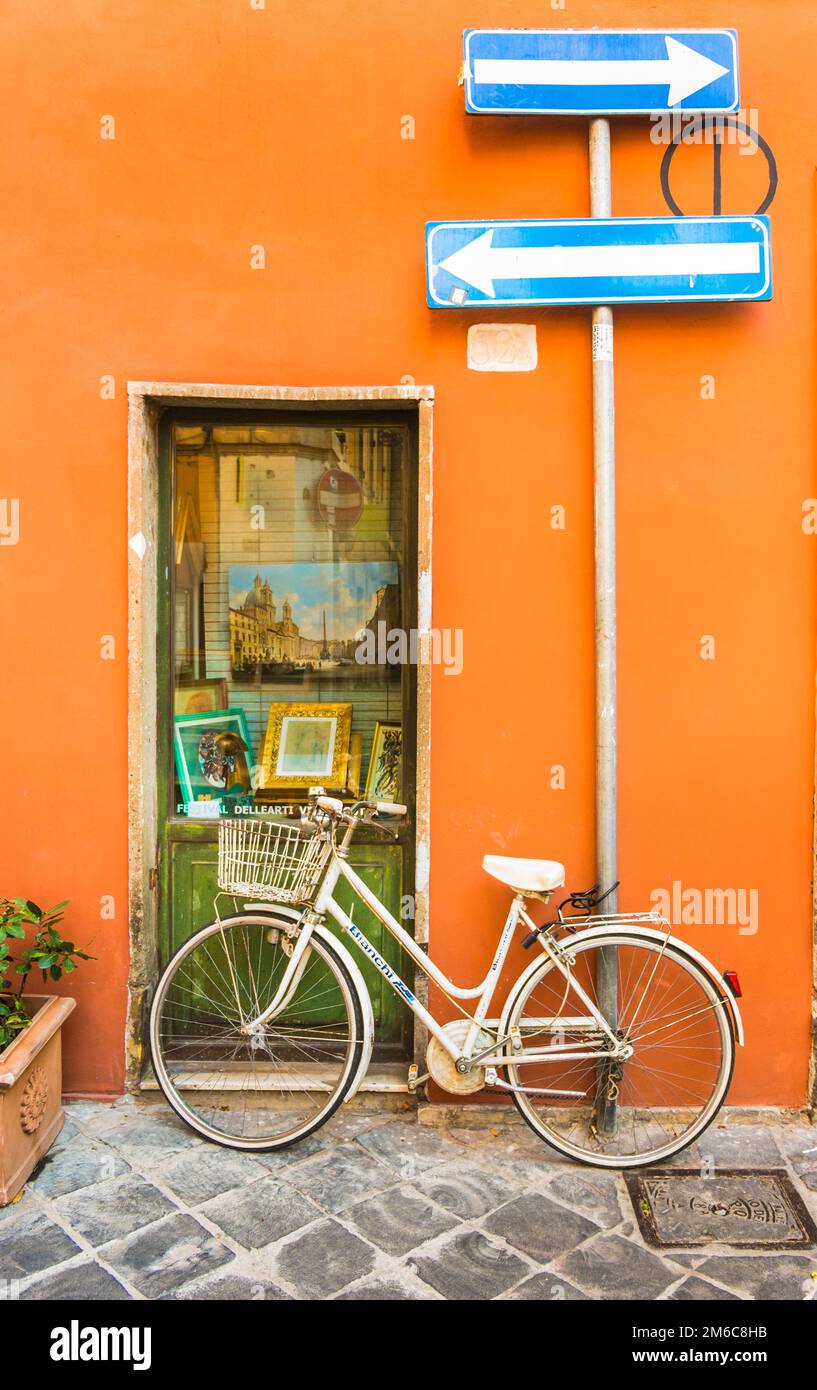 Route indicator arrows, white bicycle and painting in the shop window ...