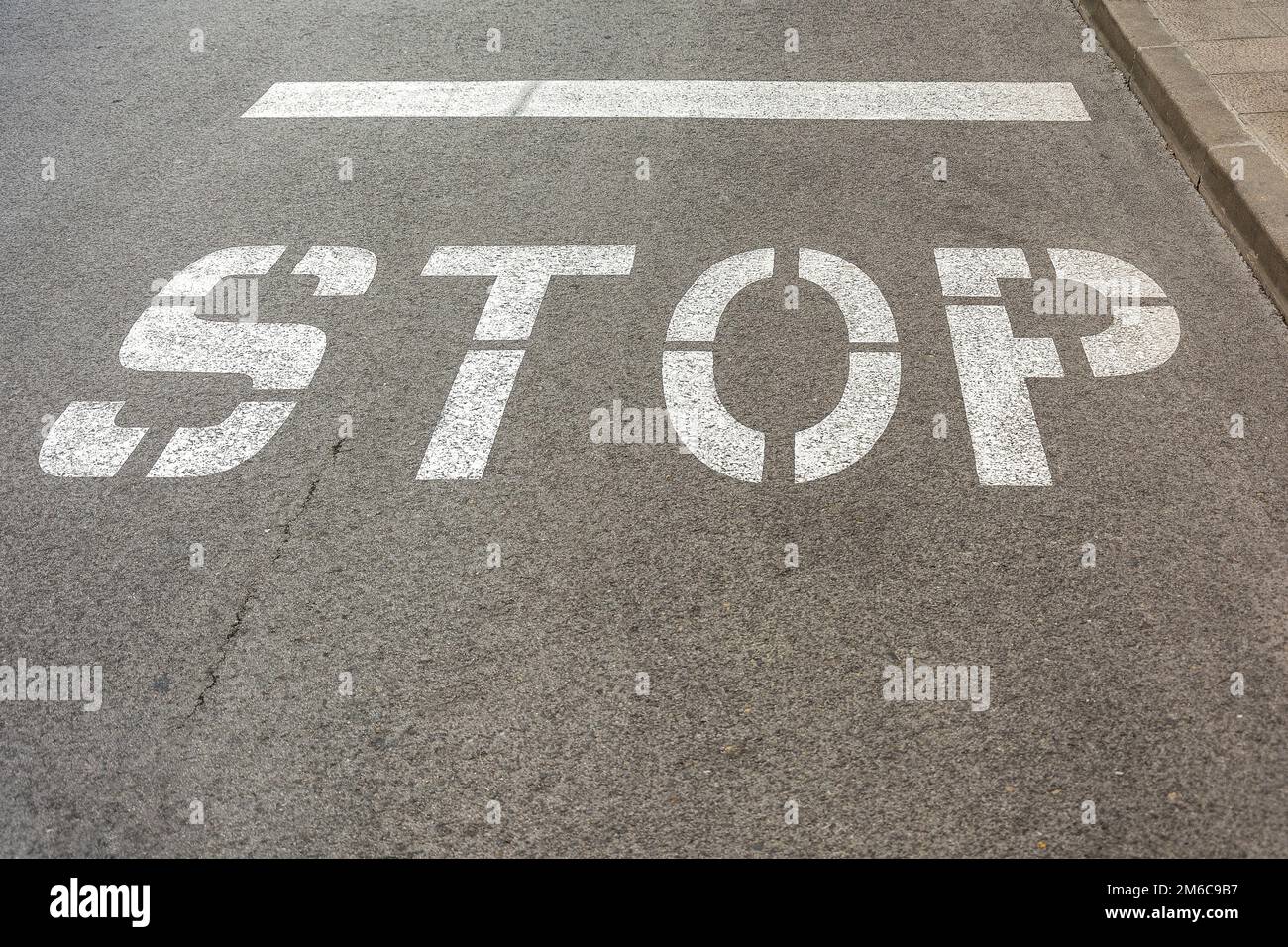 On the asphalt roadway marked the road marking STOP Stock Photo - Alamy