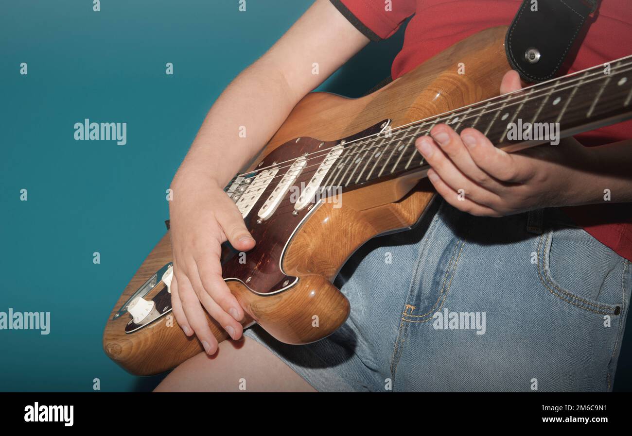 Teenager learning to play the electric guitar. Close-up Stock Photo - Alamy