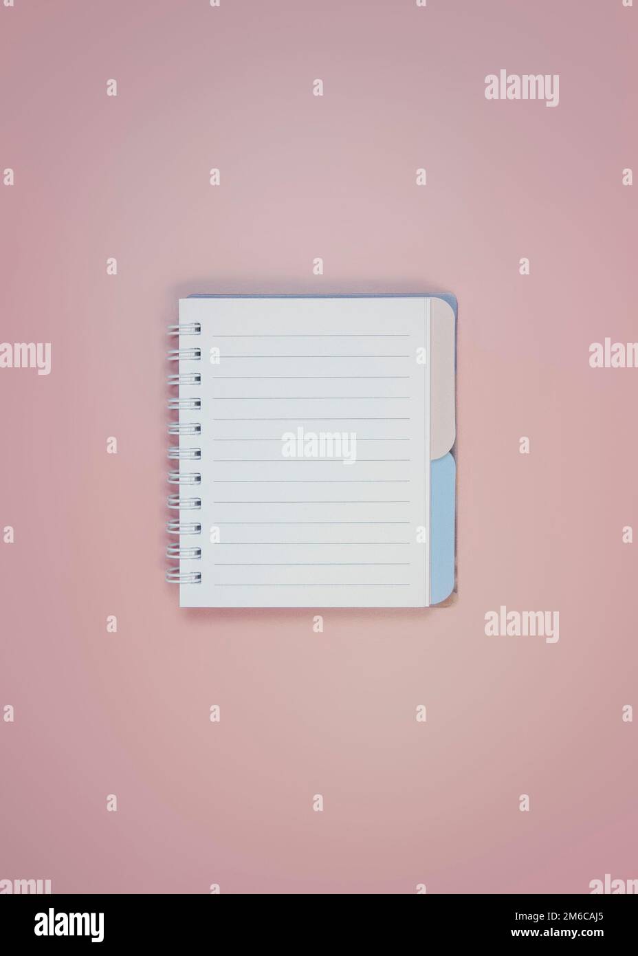 Open small notebook with blue and beige bookmarks on peach background ...