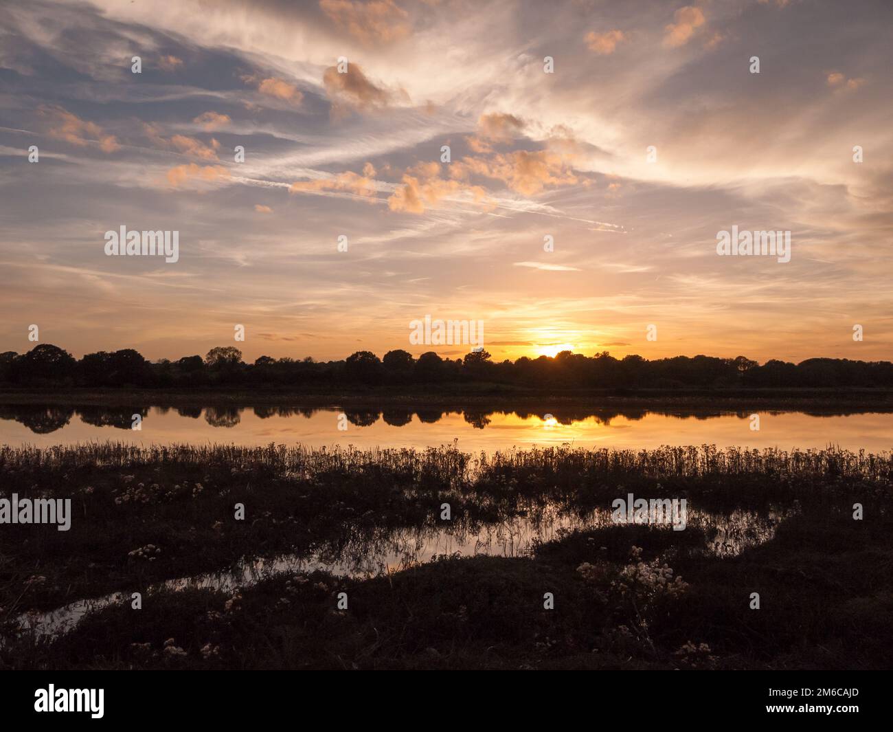 Stunning bright autumn harvest sun set scene over lake water reflection ...