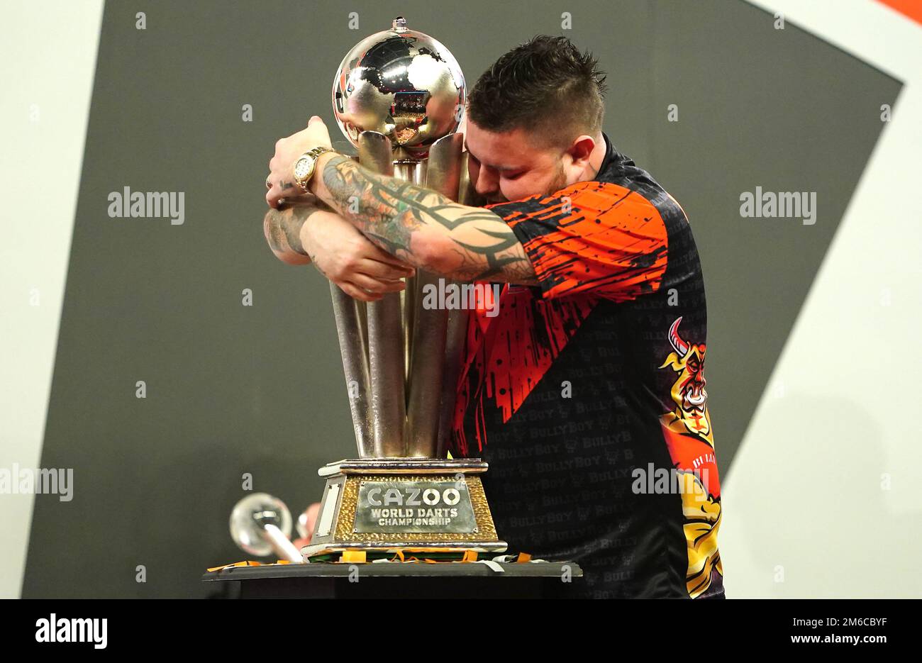 Michael Smith celebrates by hugging the Sid Waddell trophy after ...