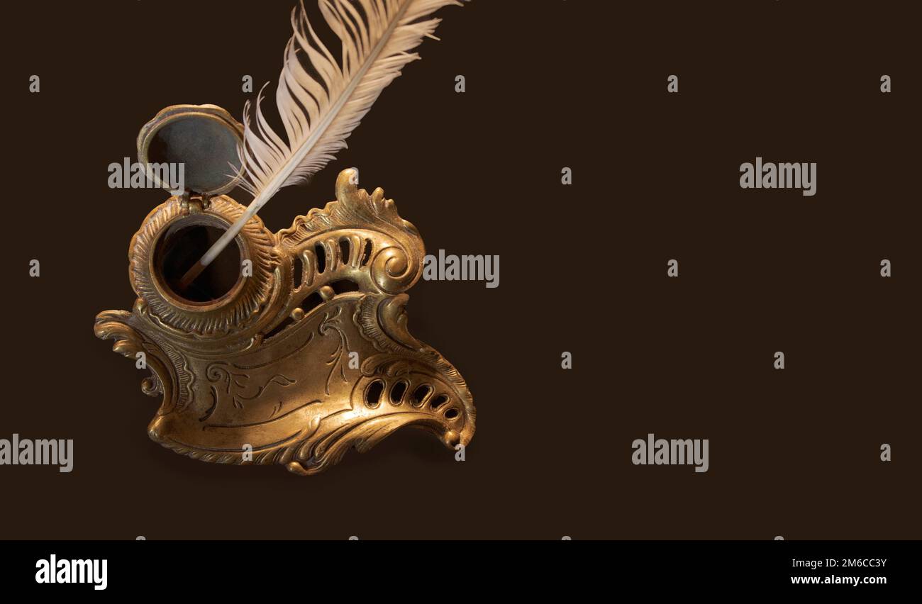 Decorative copper inkwell with nib for writing on black background, top ...